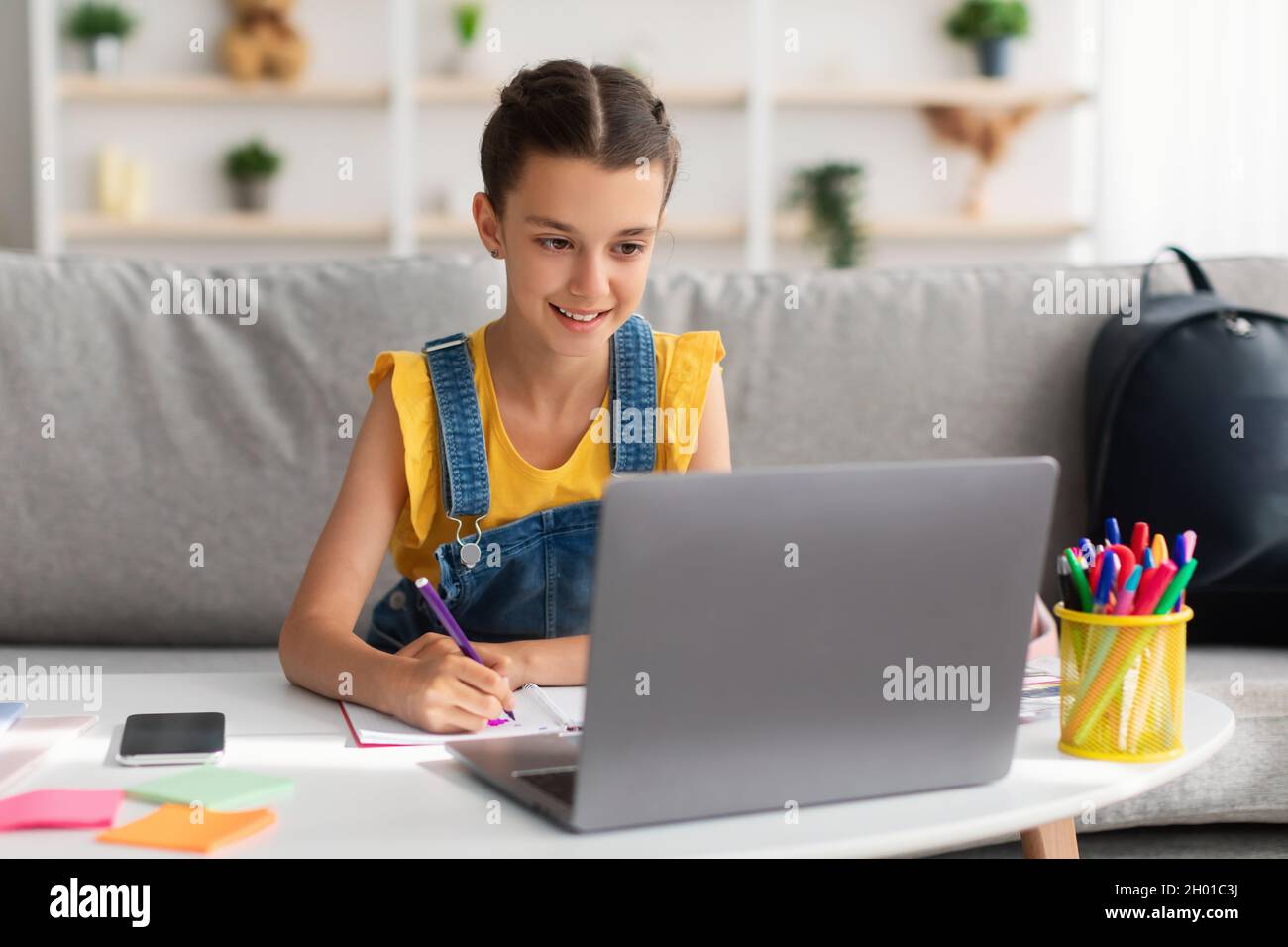 Portrait of smiling little girl drawing at home, using pc, happy ...