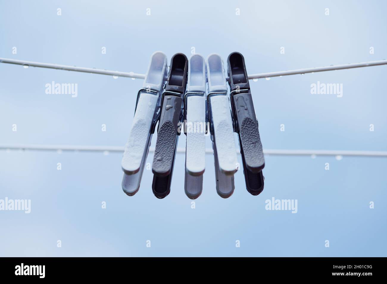 clothespins on a clothesline with water drops Stock Photo - Alamy