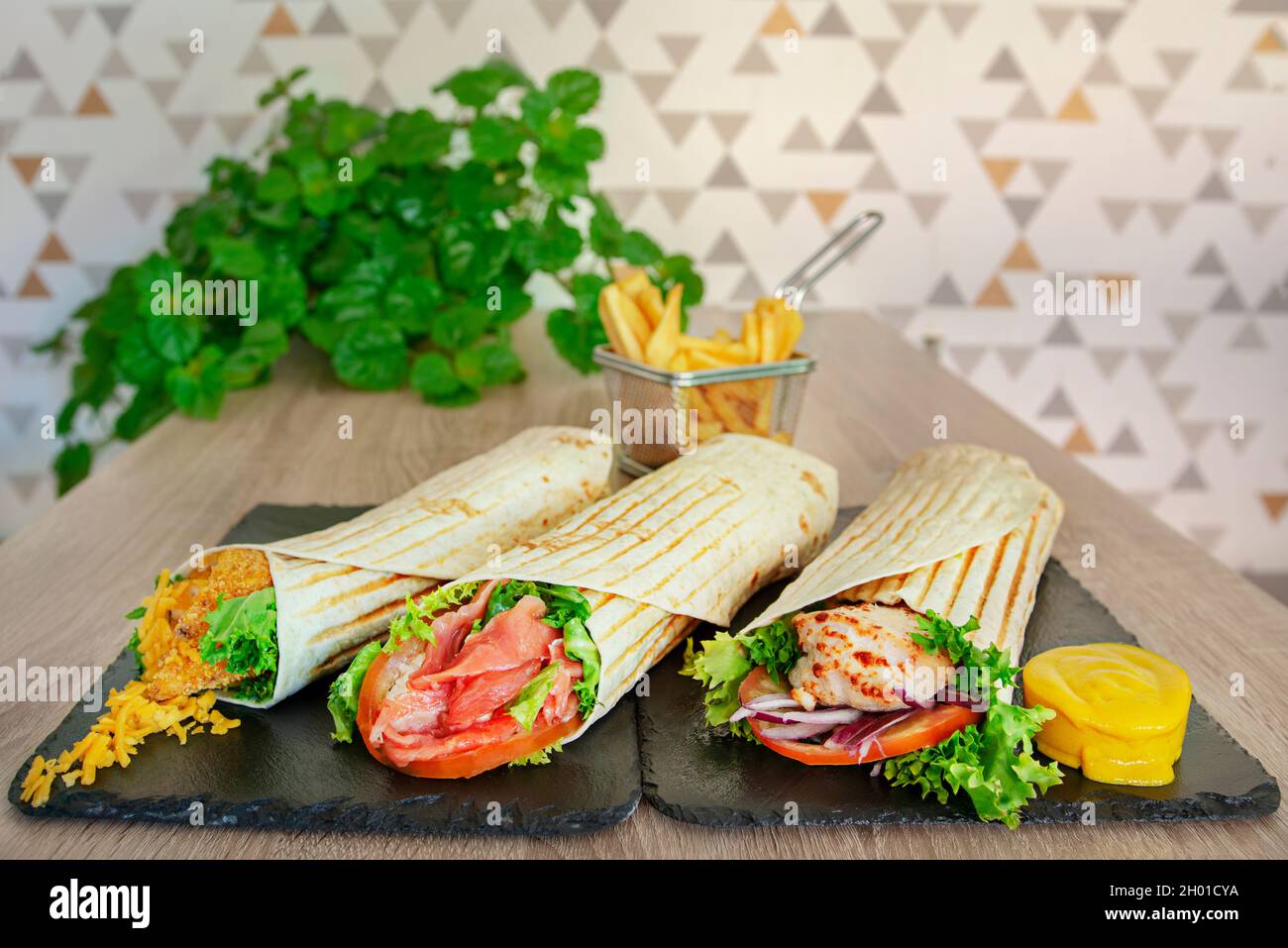 assortment of wraps stuffed with fried chicken battered with vegetables ...