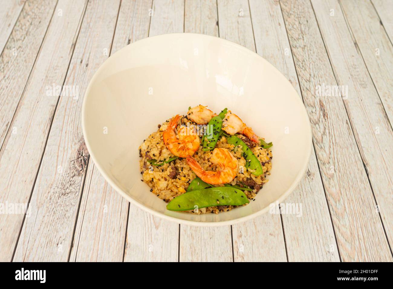 Bowl of Japanese teppanyaki fried rice with sesame seeds with green ...