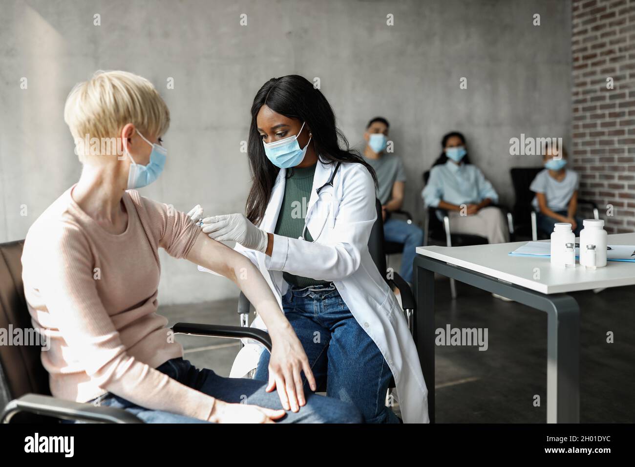 Blonde woman patient getting intramuscular shot against COVID-19 at ...