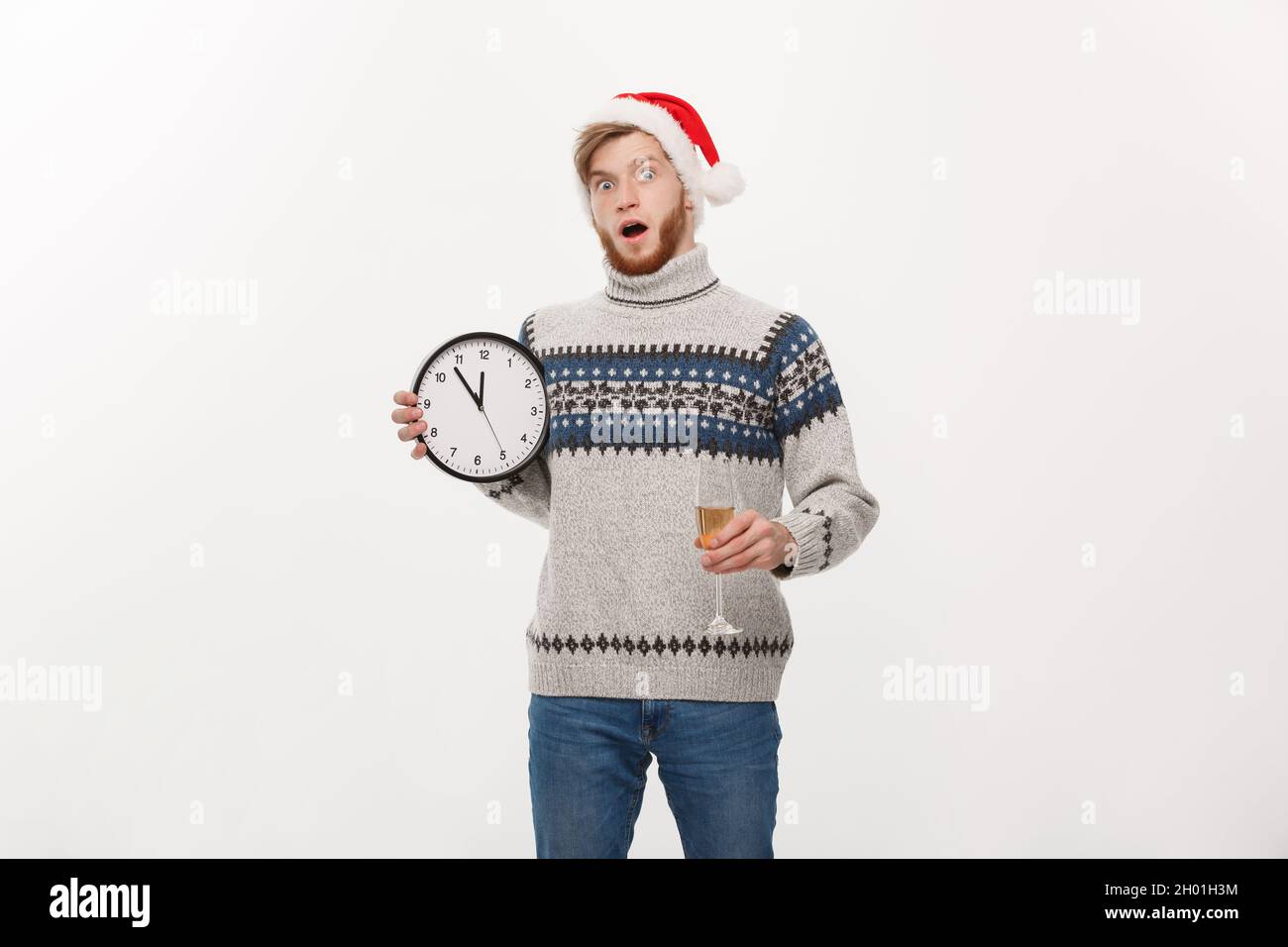 Holiday concept - Young handsome beard man in sweater with white clock ...