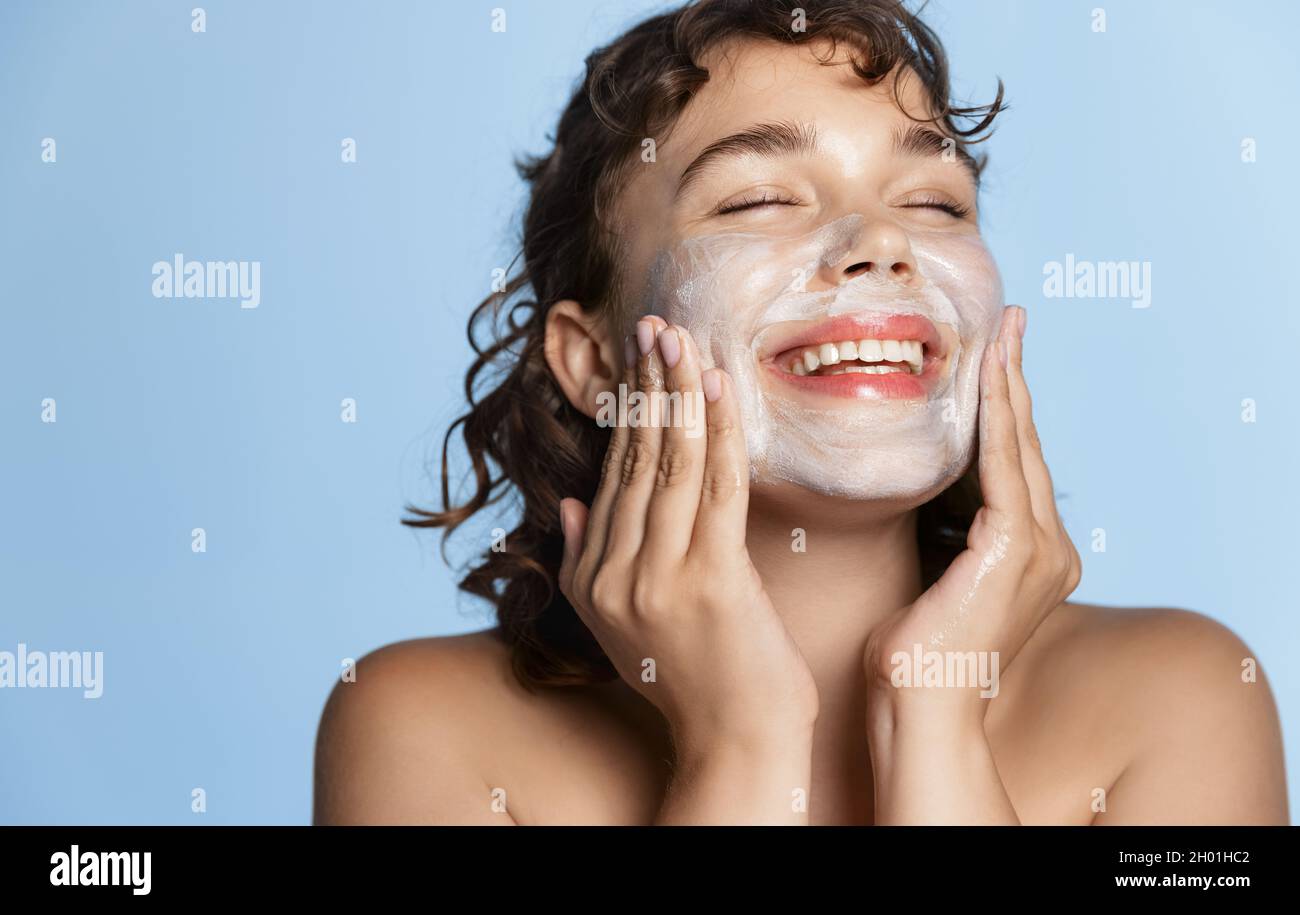 Cosmetic procedure and daily care. Beautiful laughing model washing ...