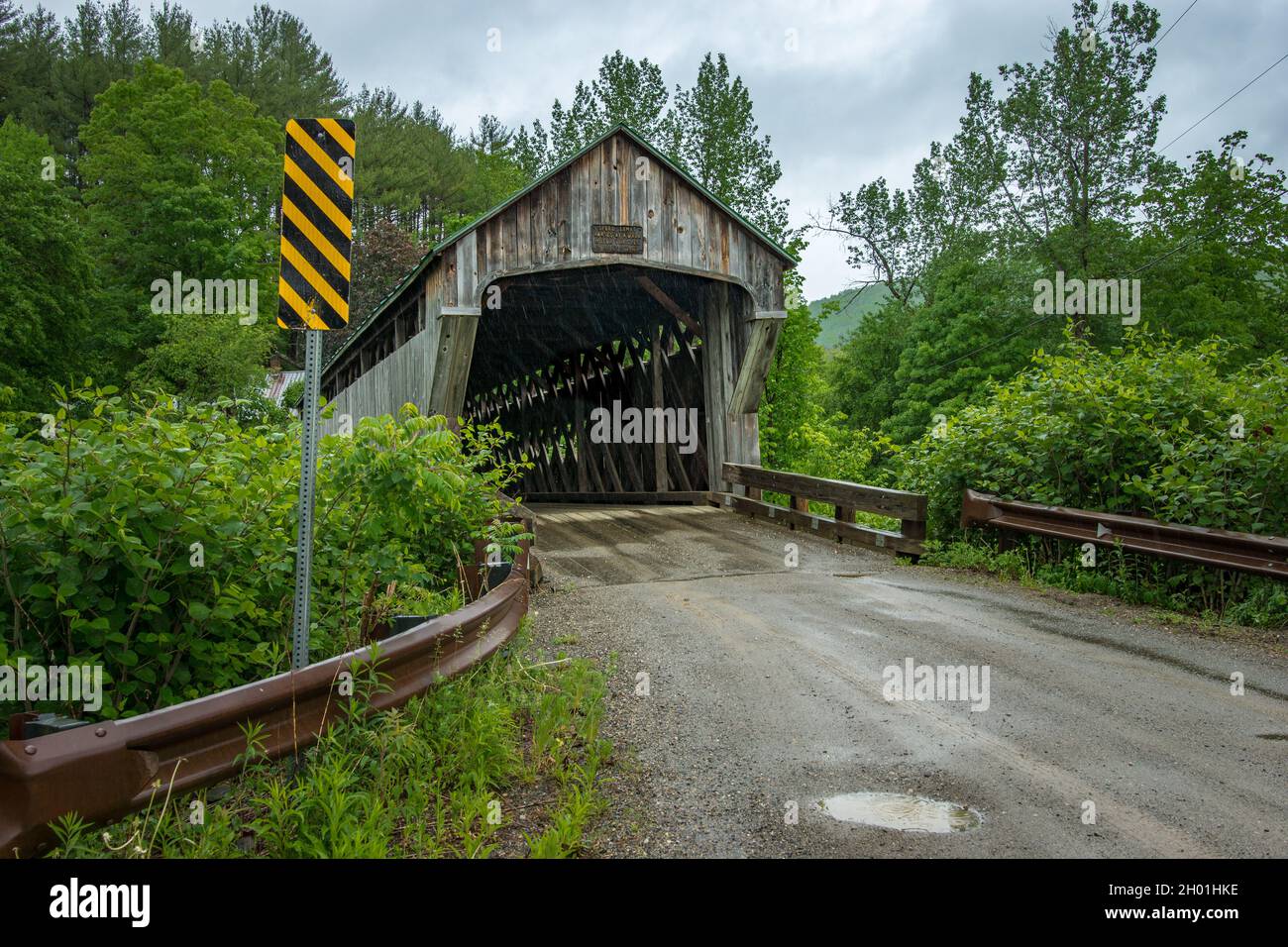 An old wooden tunnel over an asphalt road surrounded by trees Stock ...