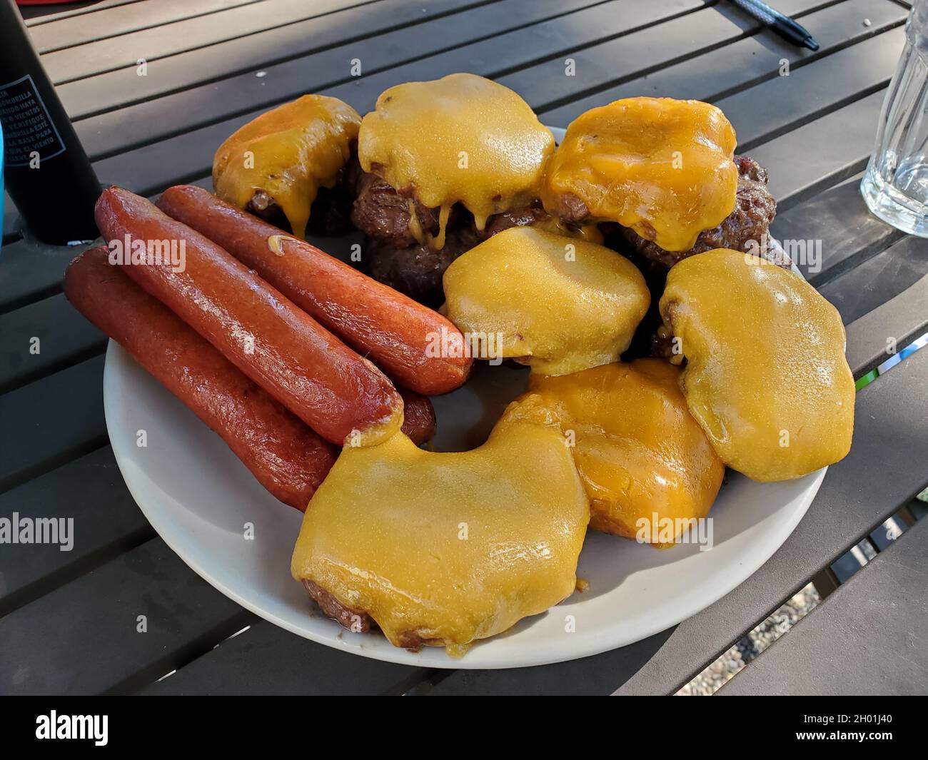 Homemade cheeseburgers and hot dogs are visible during a cookout in ...