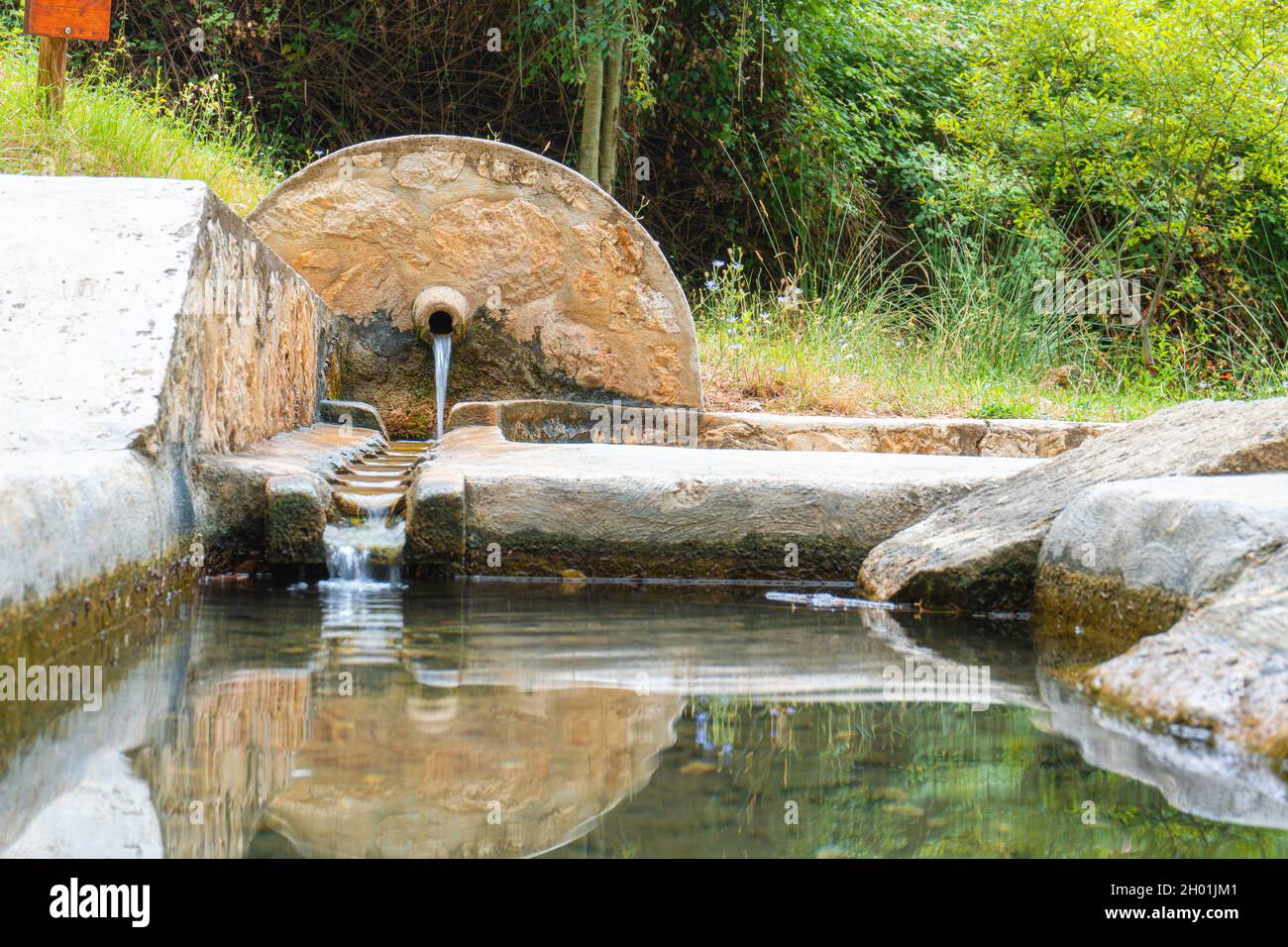 The water flowing from stone pipe in nature Stock Photo - Alamy