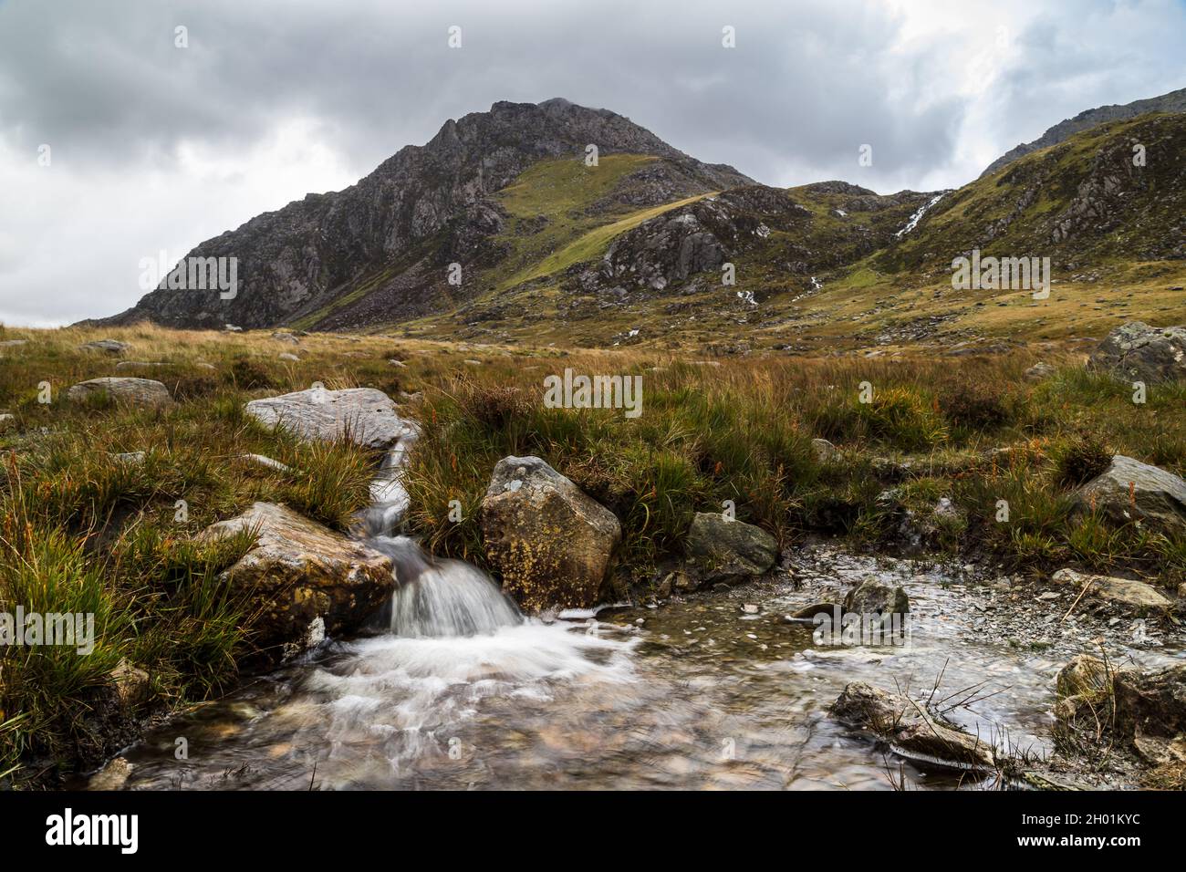 Rain water spills into a rocky pool at Pont Pen-y-benglog in Snowdonia ...