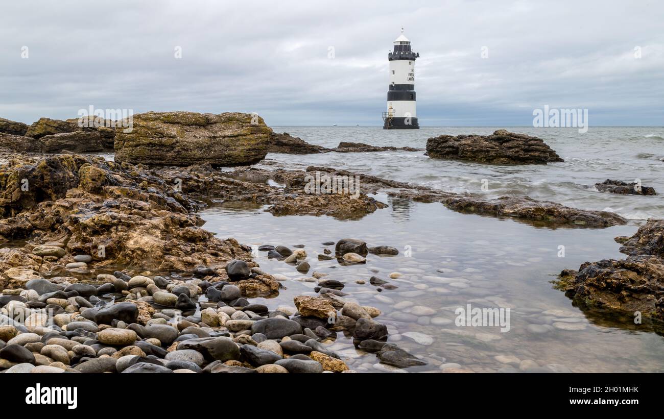 Pools of water caught between the rocks by Penmon Lighthouse on the ...