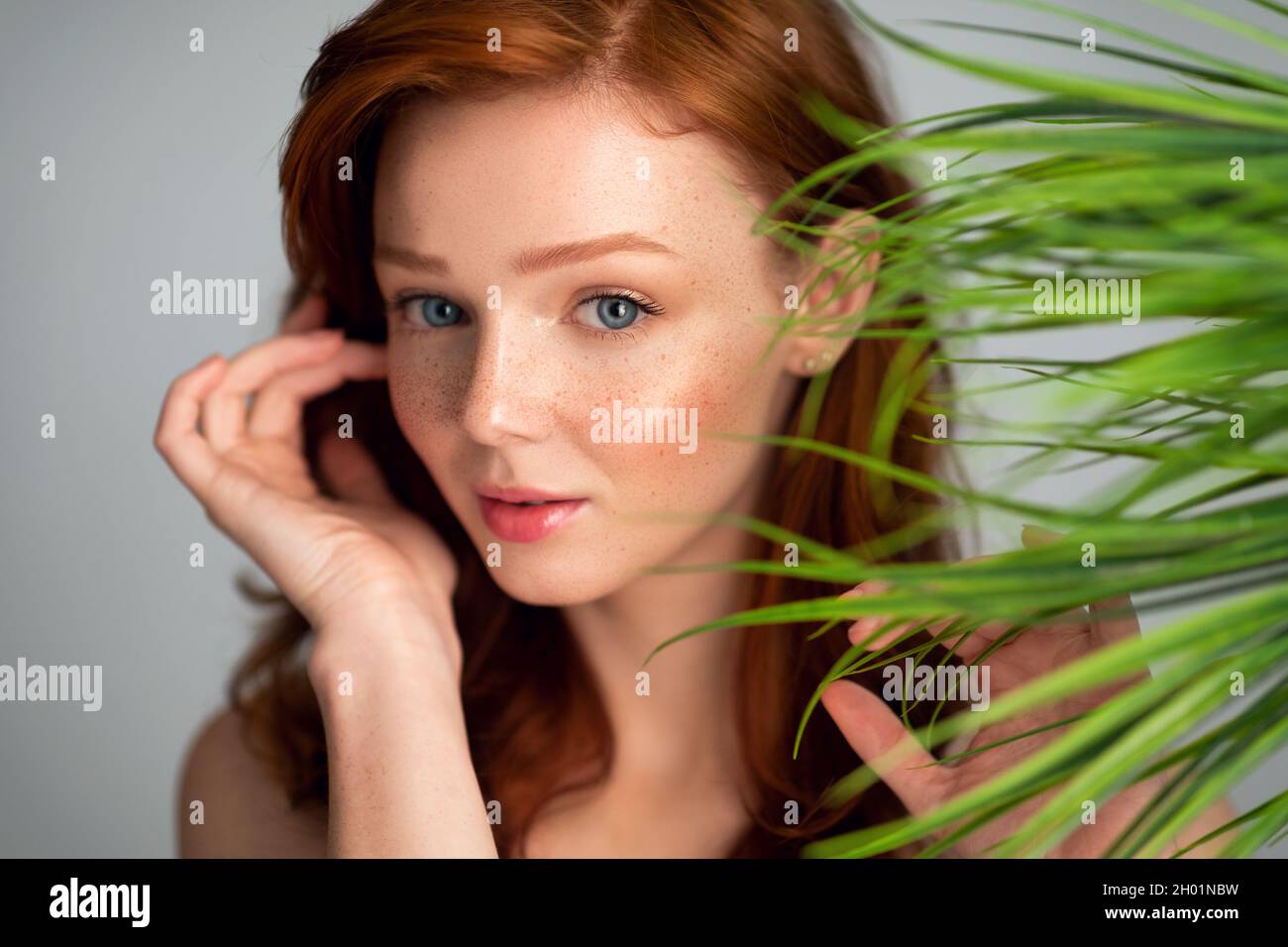 Ginger-Haired Millennial Girl Looking Through Green Grass Advertising ...
