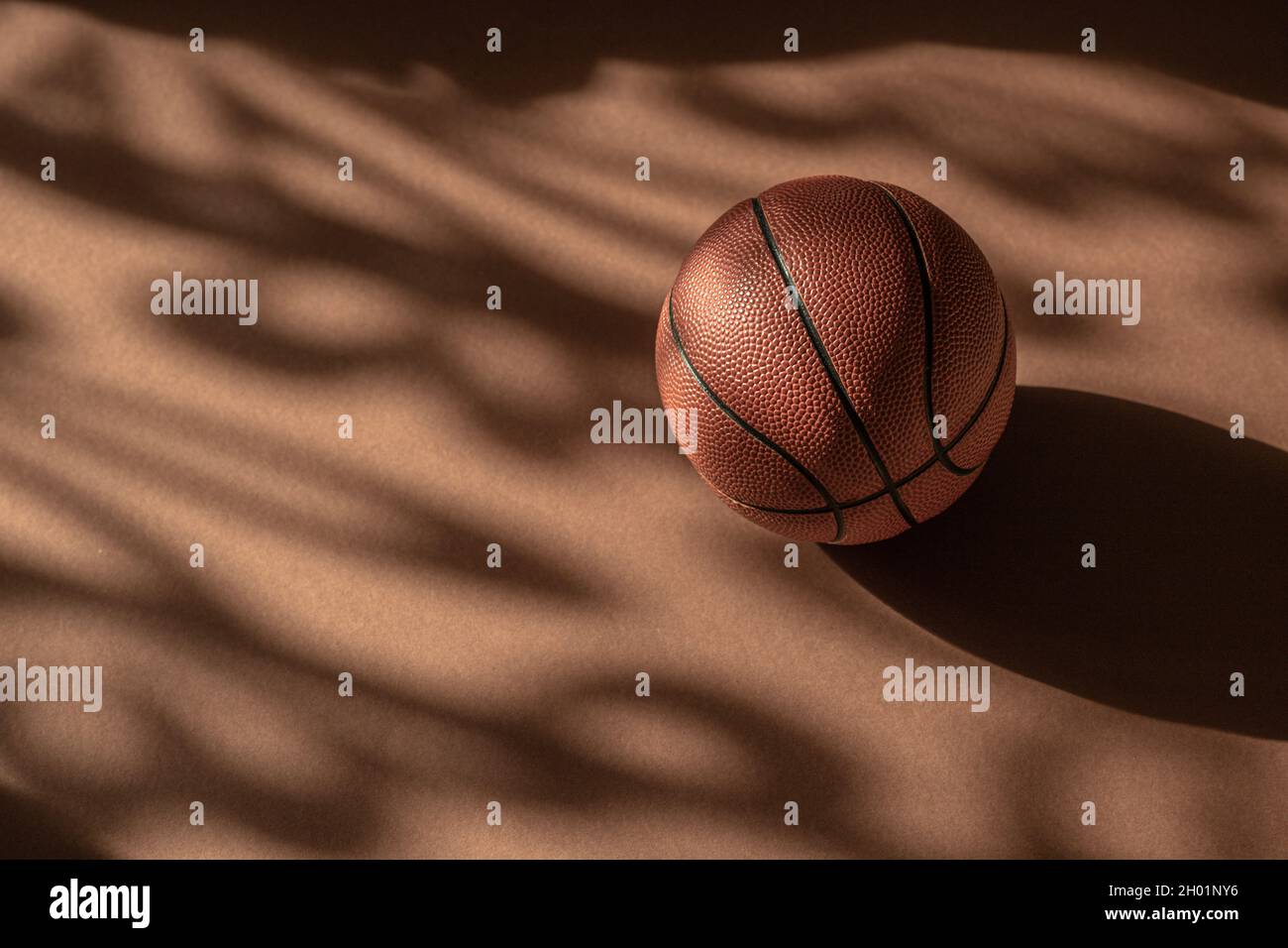 New basketball ball on brown court floor with natural lighting. Workout ...