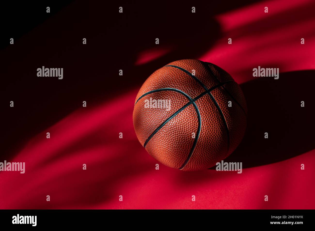 Basketball on red court floor with natural lighting. Workout online ...