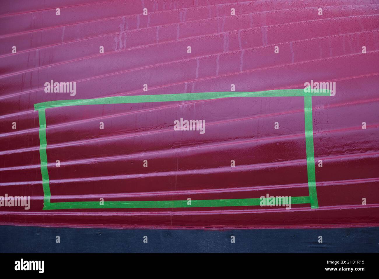 Green rectangle taped on the side of a red boat Stock Photo - Alamy
