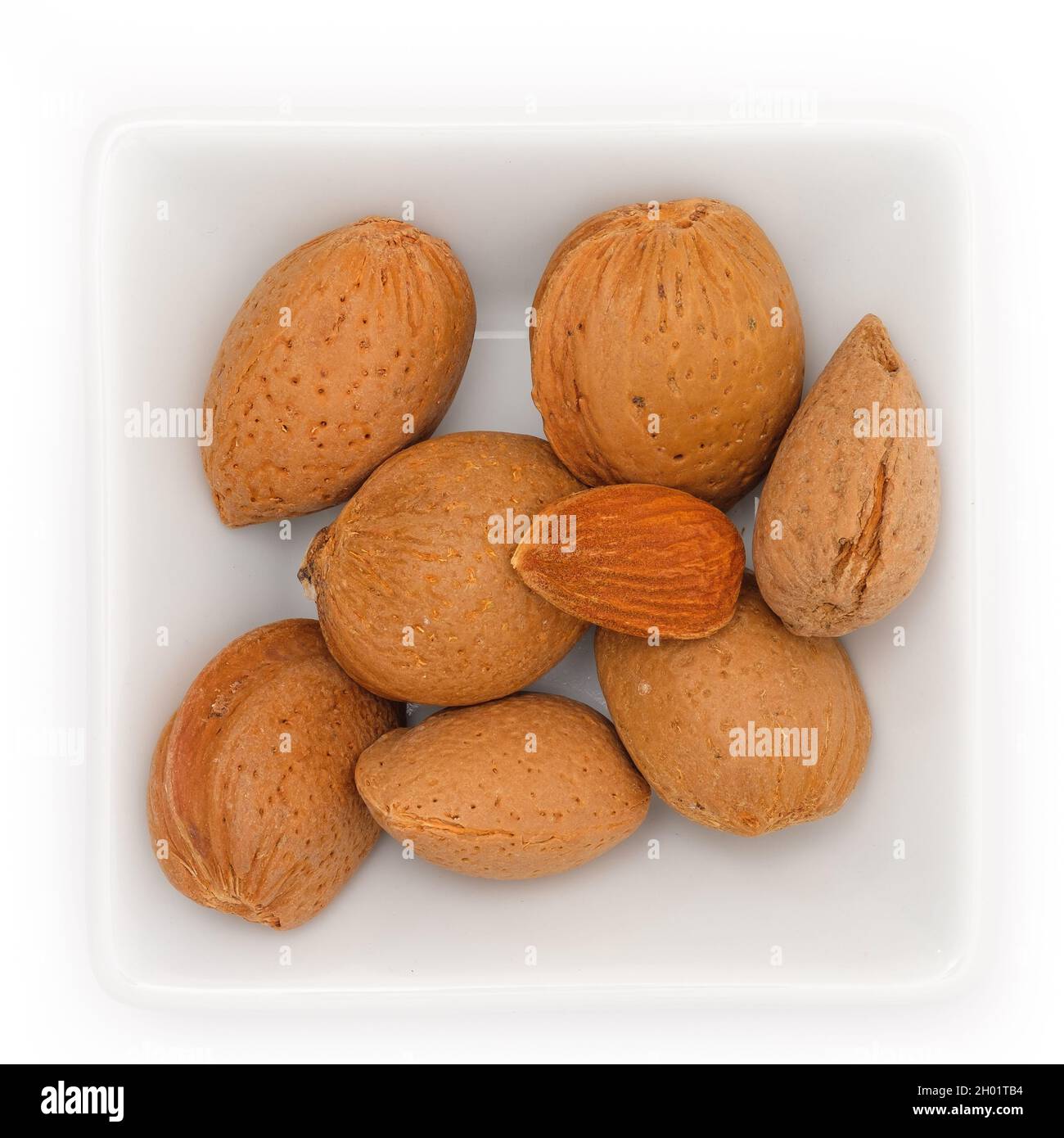 A top view of almond kernels with shell in a bowl Stock Photo - Alamy