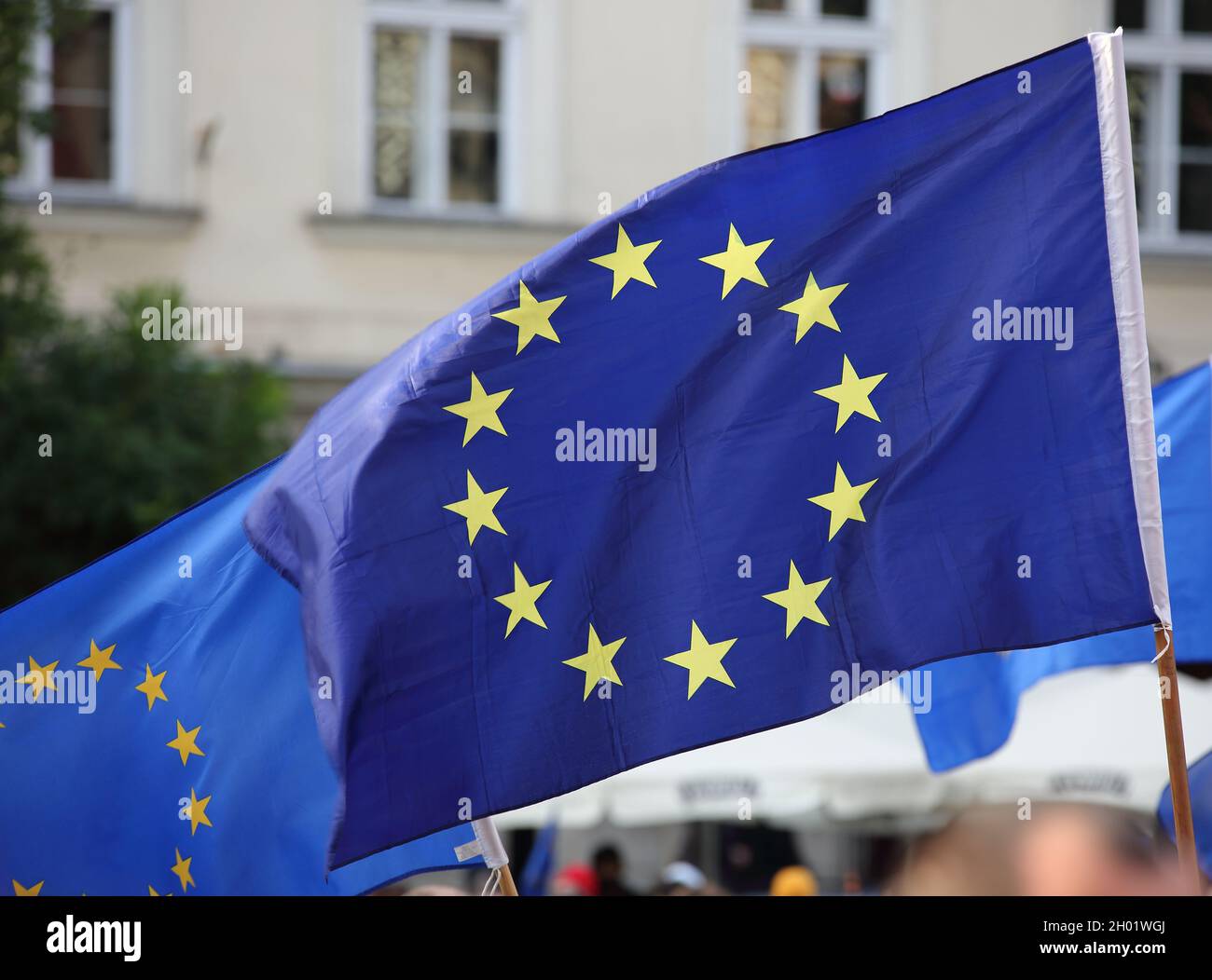 Flags of European Union on flagpoles wvaes in urban area, city, during ...