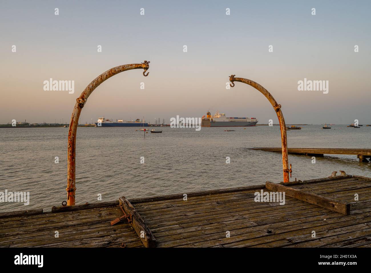 Old lifeboat davits on jetty at Gravesend Promenade with Ro-ro ferries ...