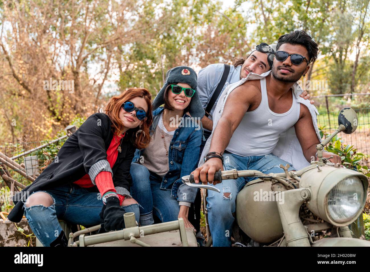 group of best friends together have fun riding a vintage motorcycle ...