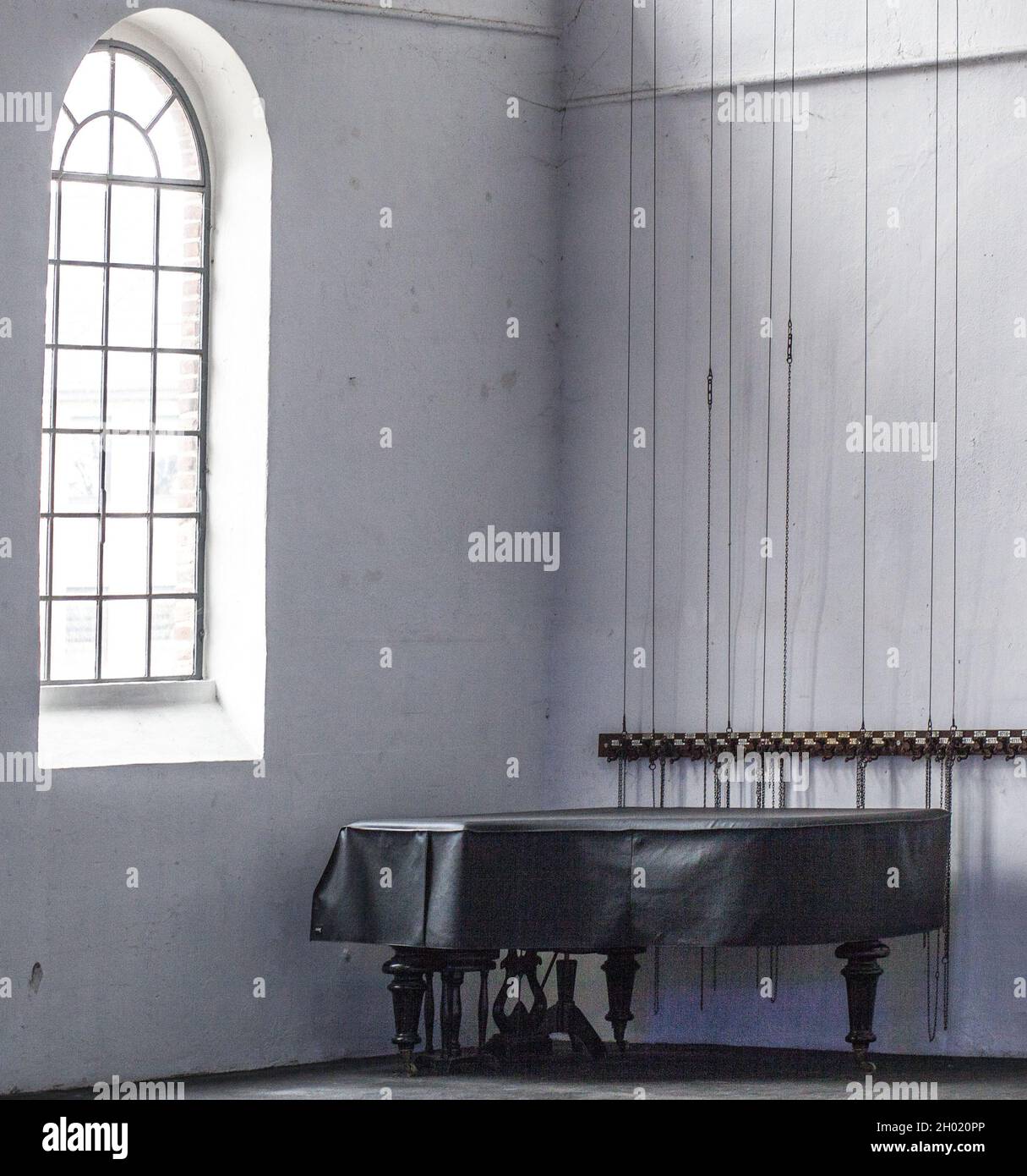 A piano covered by black fabric Stock Photo - Alamy