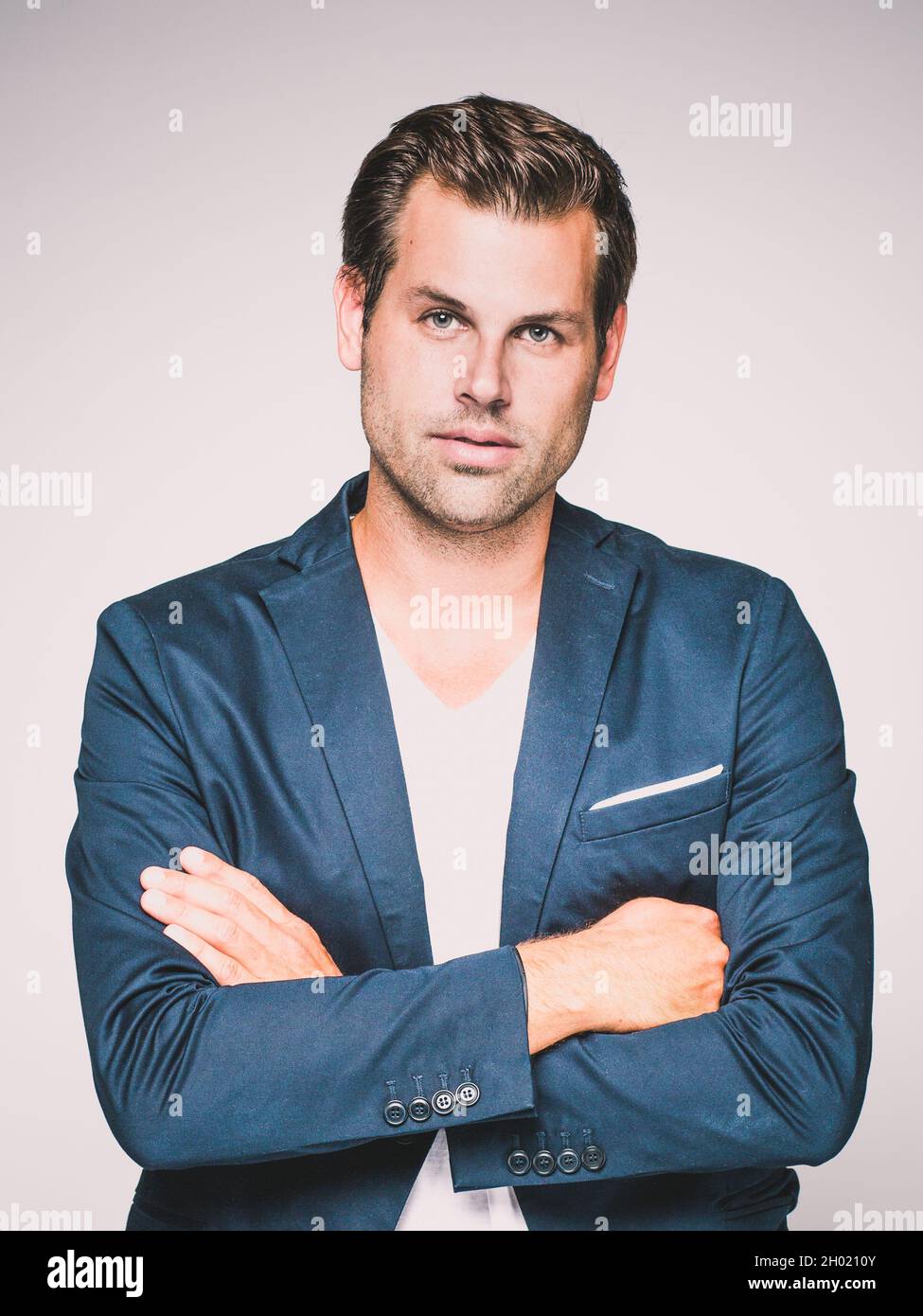 Portrait of a smart young man standing with arms crossed Stock Photo ...