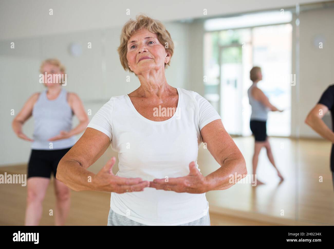 Elderly woman practicing ballet dance moves in choreographic studio ...