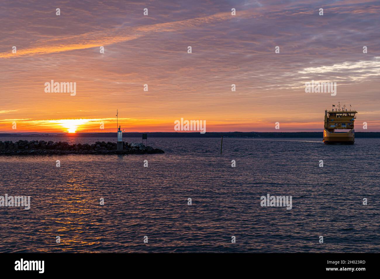 Sunset with ferry coming in towards the harbour Stock Photo - Alamy