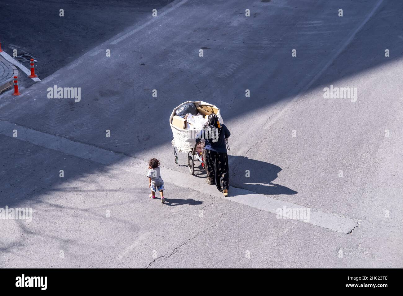 A mother with a child rolling a cart in the street Stock Photo - Alamy