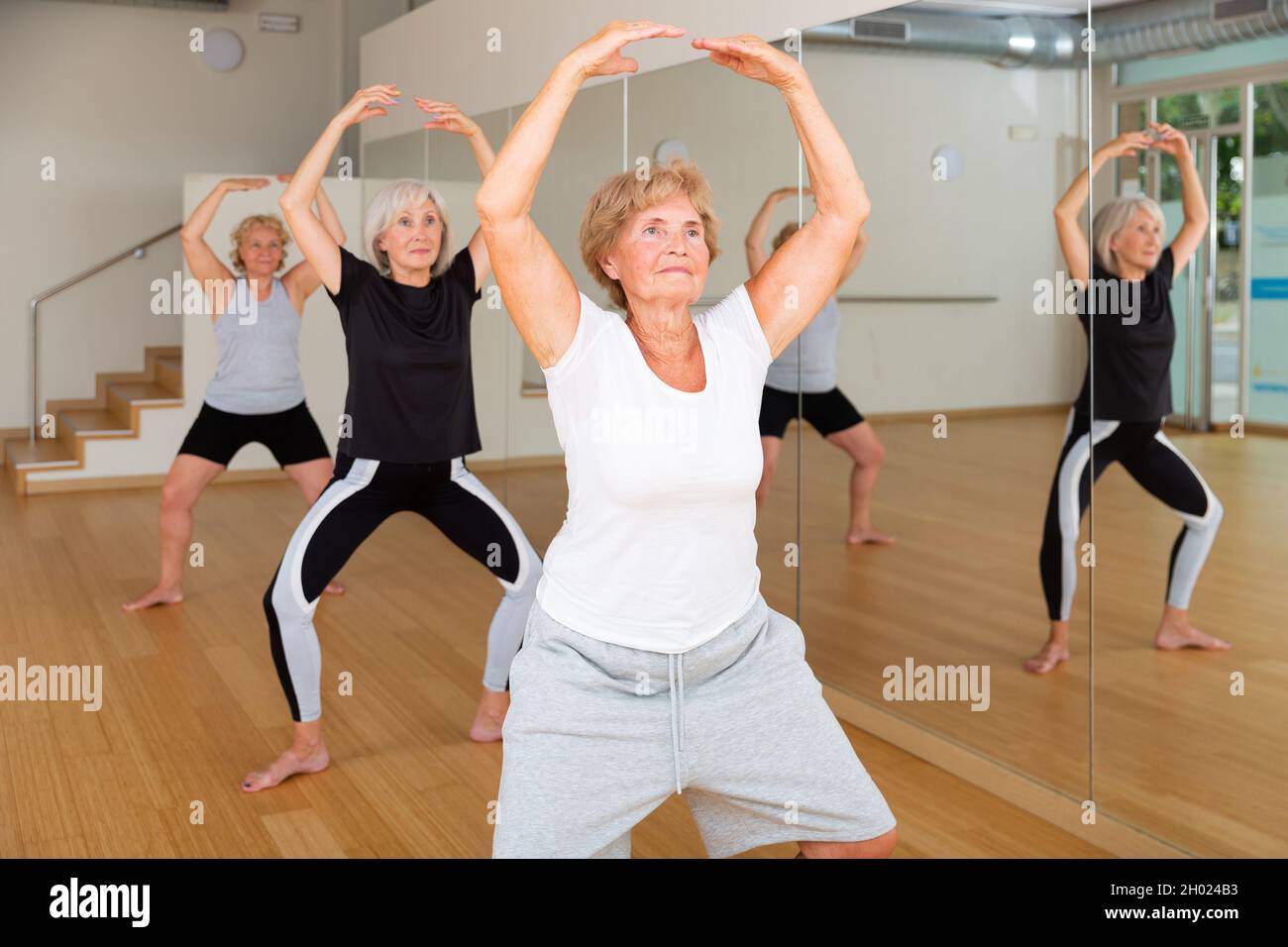 Elderly woman practicing ballet dance moves in choreographic studio ...