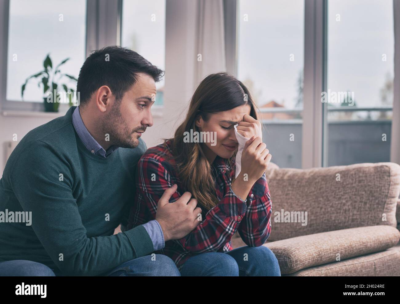 Man consoling sad girl at home with hug and his presence Stock Photo ...