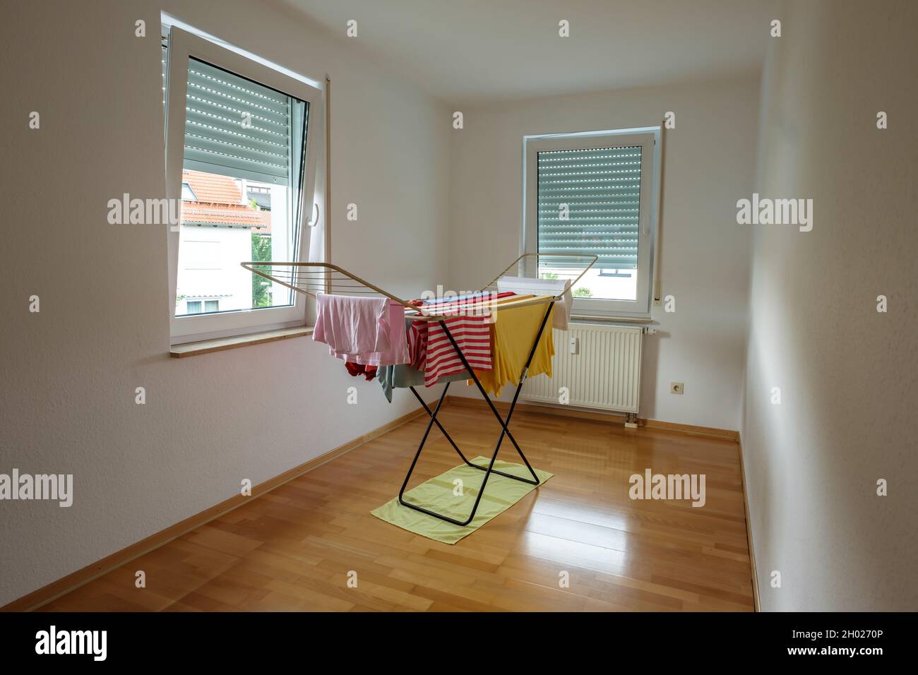 A clothes horse with laundry in a room with windows Stock Photo - Alamy