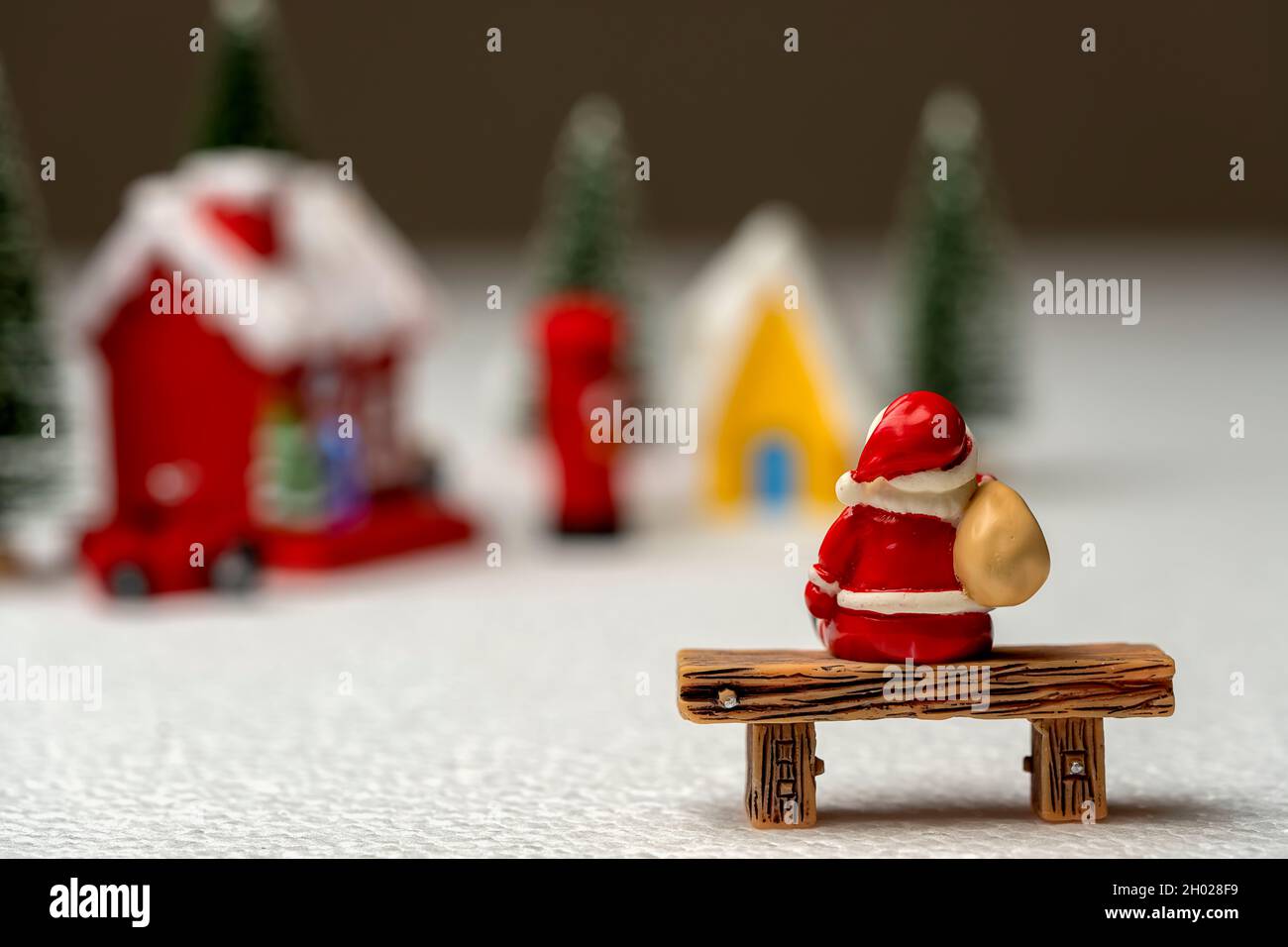 Santa Claus carrying a bag sitting on a bench Stock Photo - Alamy
