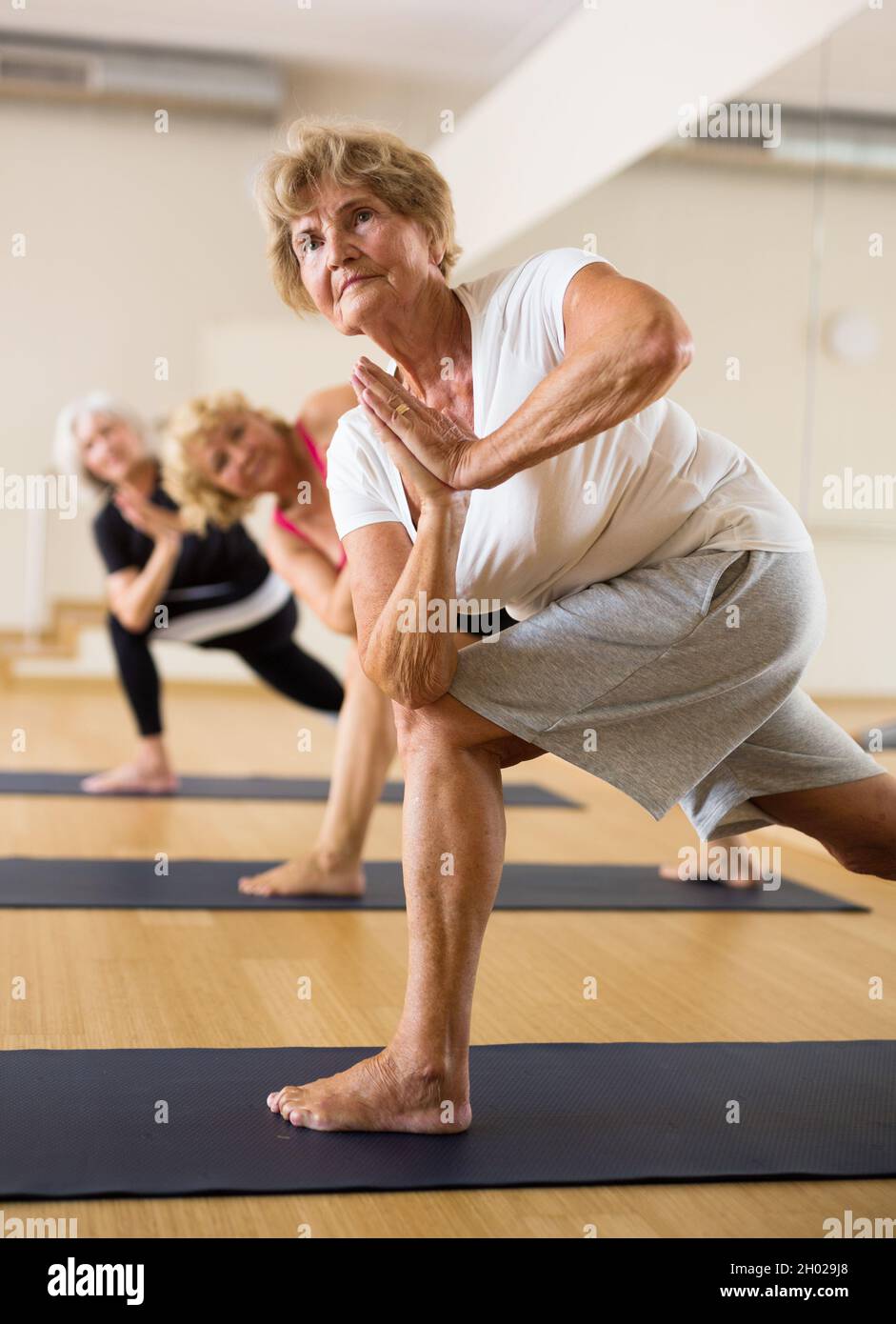 Mature women perform the exercise in the twisted side angle pose Stock ...