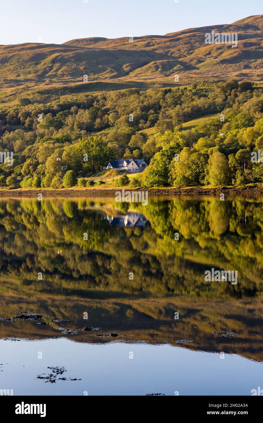 Perfect reflections on a beautiful Scottish Loch in the early morning ...