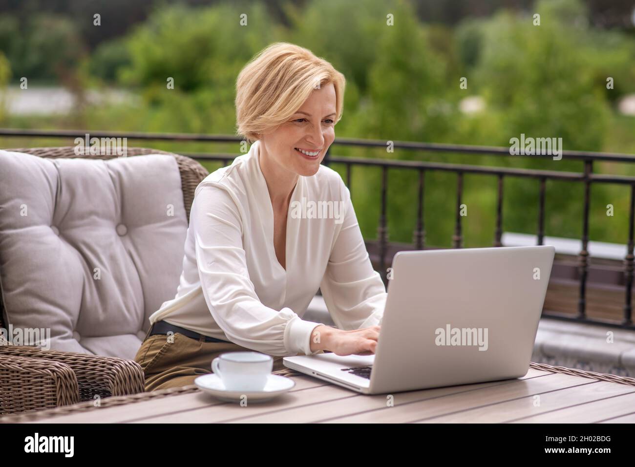 Joyful woman writing an email on the notebook computer Stock Photo - Alamy