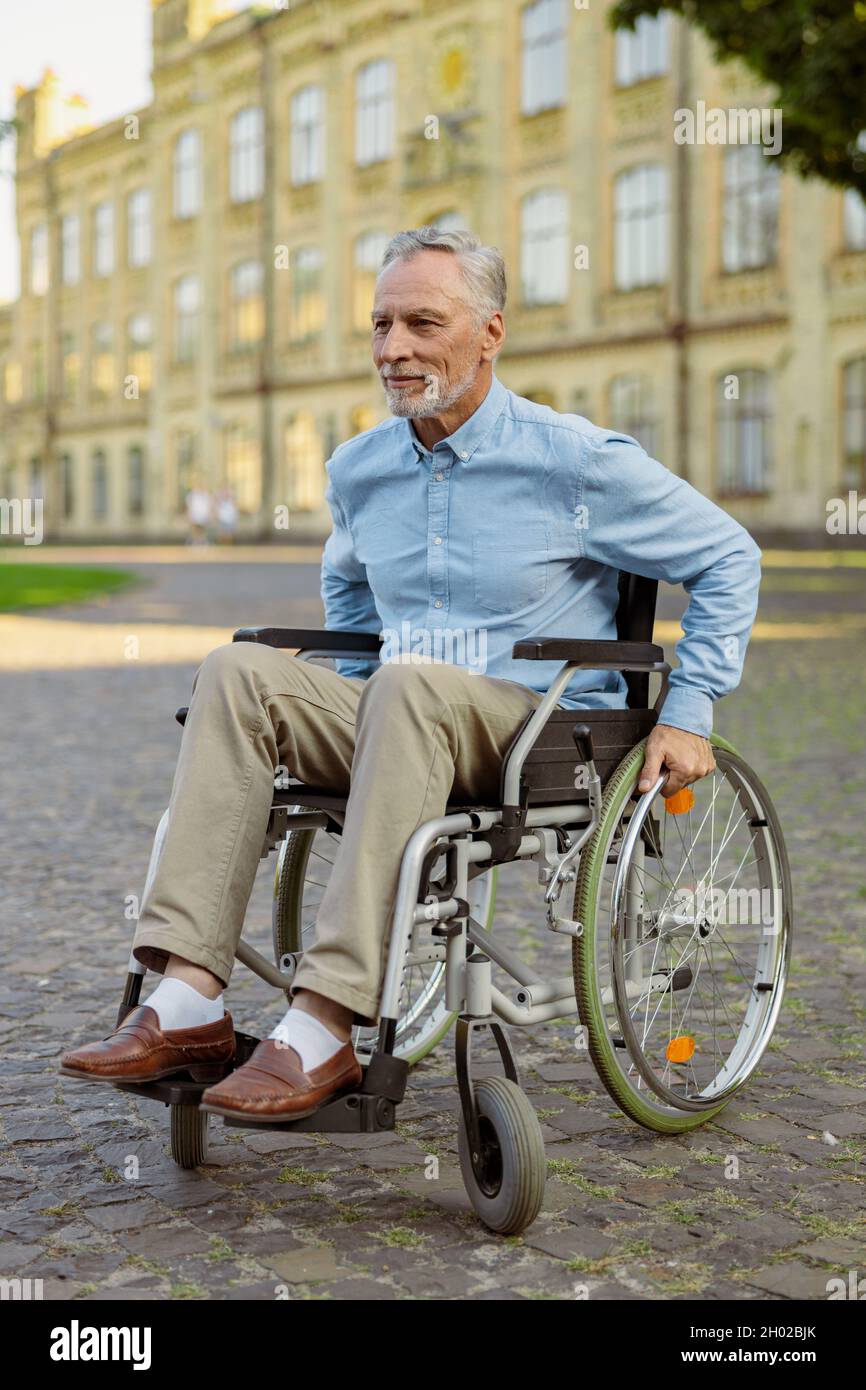 Active mature recovering man in wheelchair smiling away while spending ...
