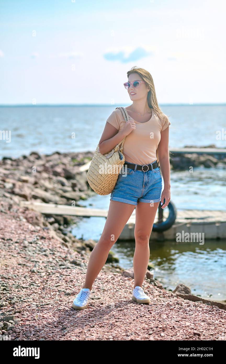 Young slim woman in shorts on the beach Stock Photo - Alamy