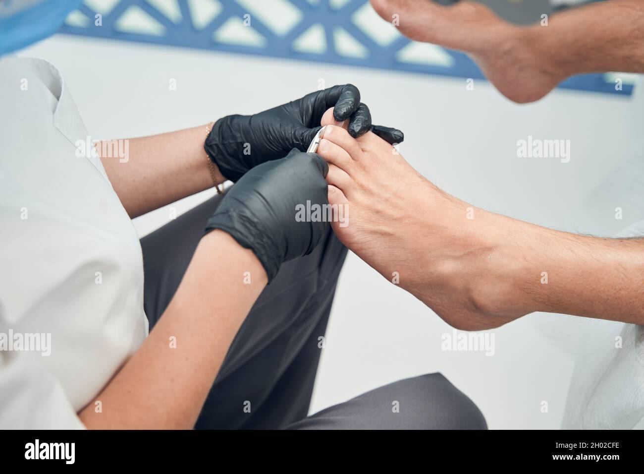 Pedicure technician cutting man toenails in cosmetology salon Stock ...