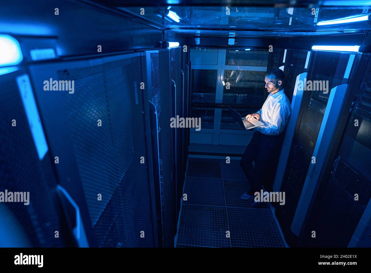 Data center operations professional programming server with laptop ...