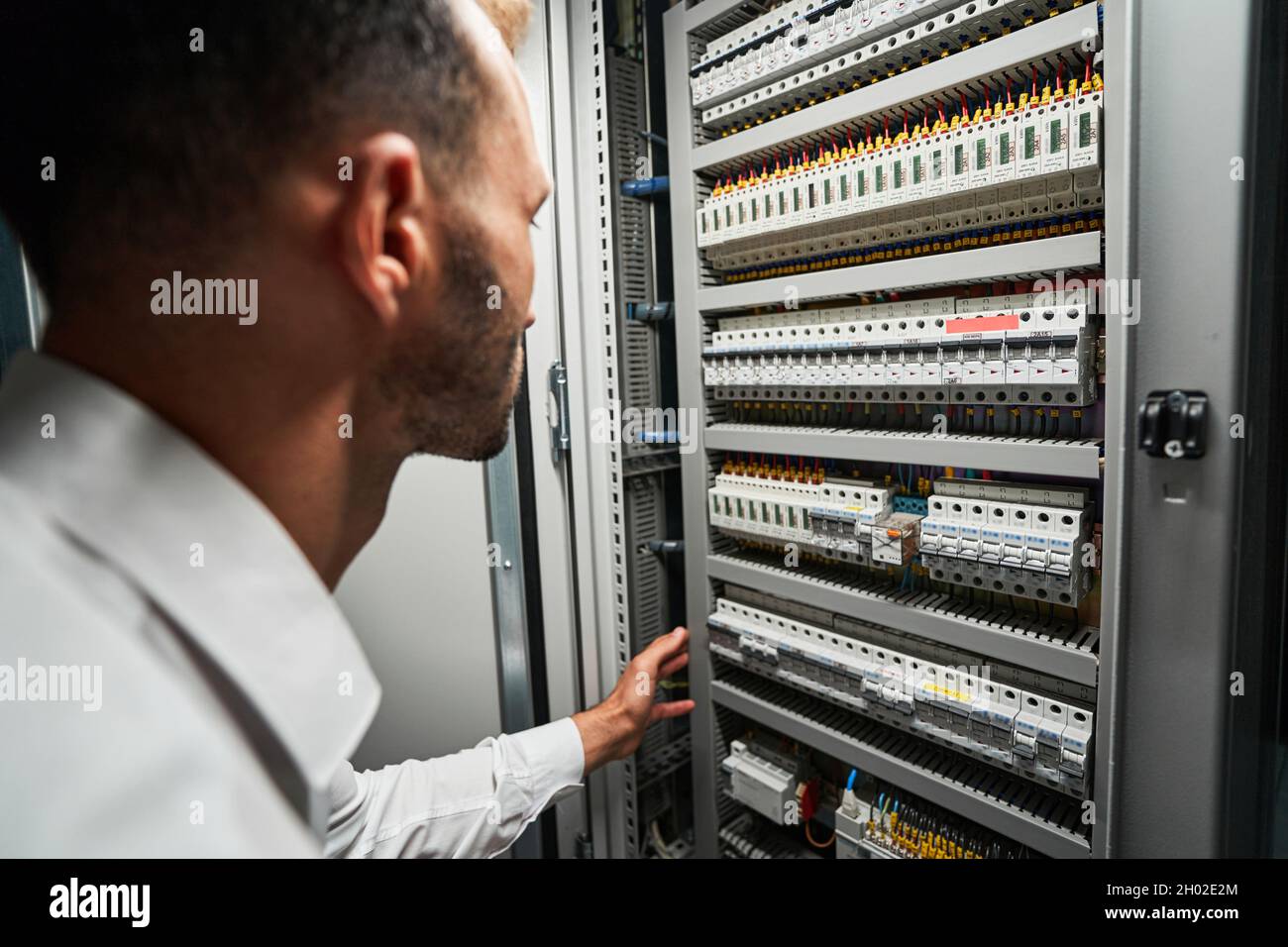 Data center worker reaching for electrical switch inside cabinet Stock ...