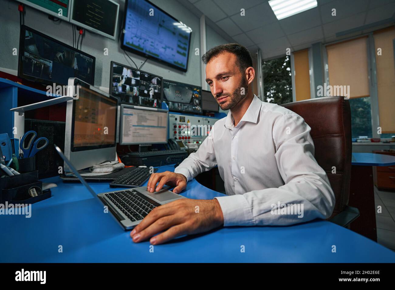 Male server administrator managing data center from control room Stock ...