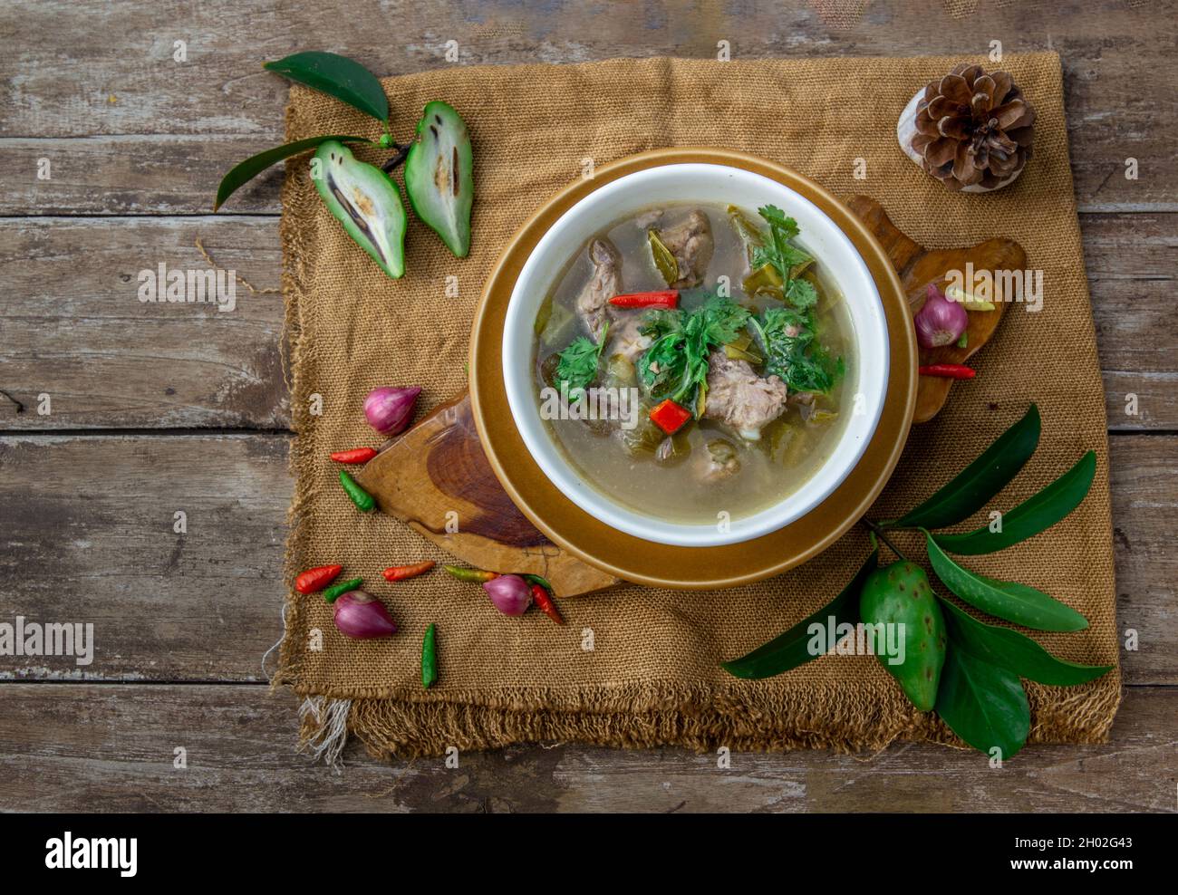 Pork spare rip Madan soup (Kra Dook Moo Tom Ma-Dun) in a white bowl ...