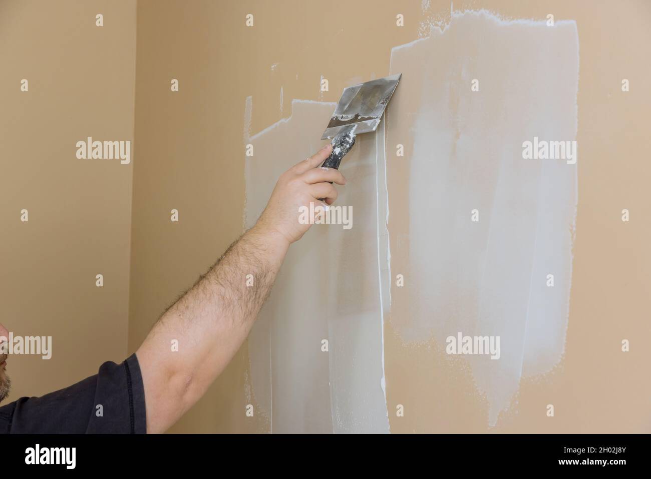 During room renovation in worker plastered the plasterboard wall Stock ...