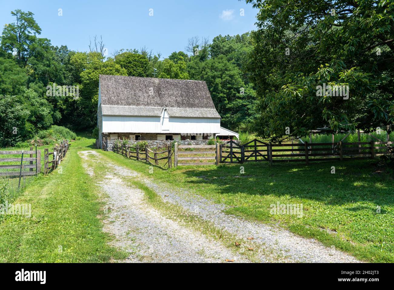 An old barn with wooden shingles surrounded by a split rail fence Stock ...