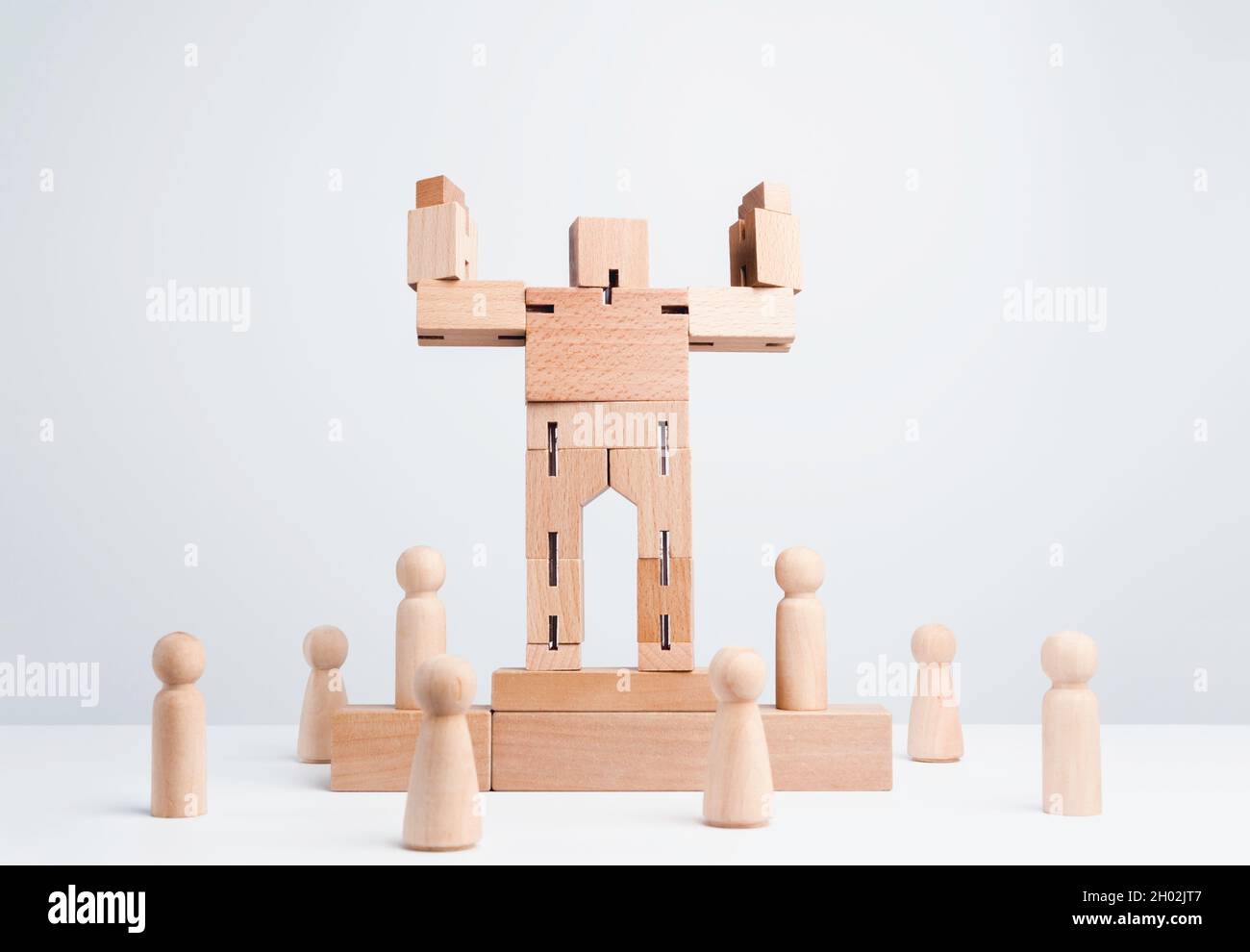 Big wooden robot strong power gesture standing on winner podium among ...