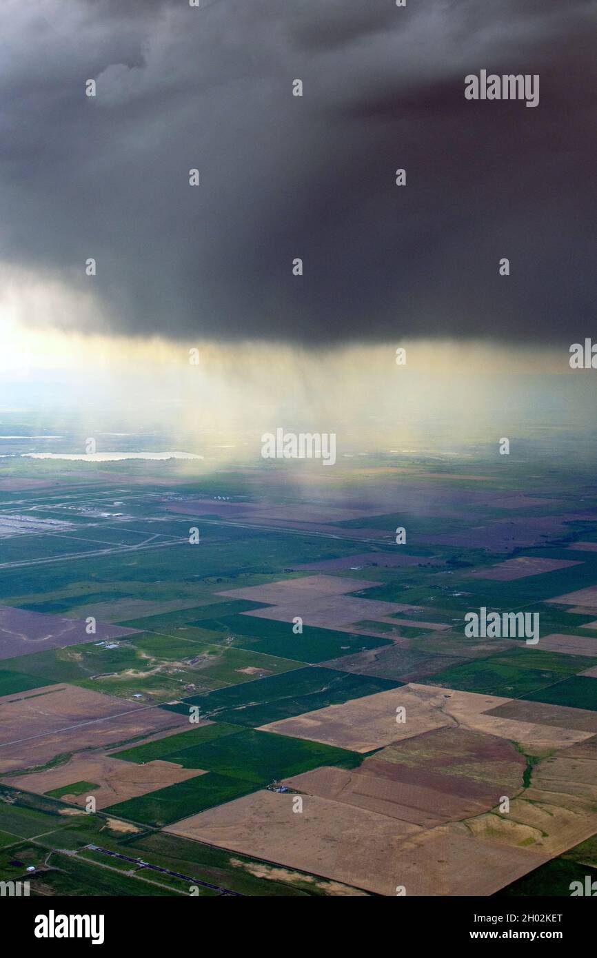 Ariel view of rain clouds pouring down on a patchwork of land, from the ...
