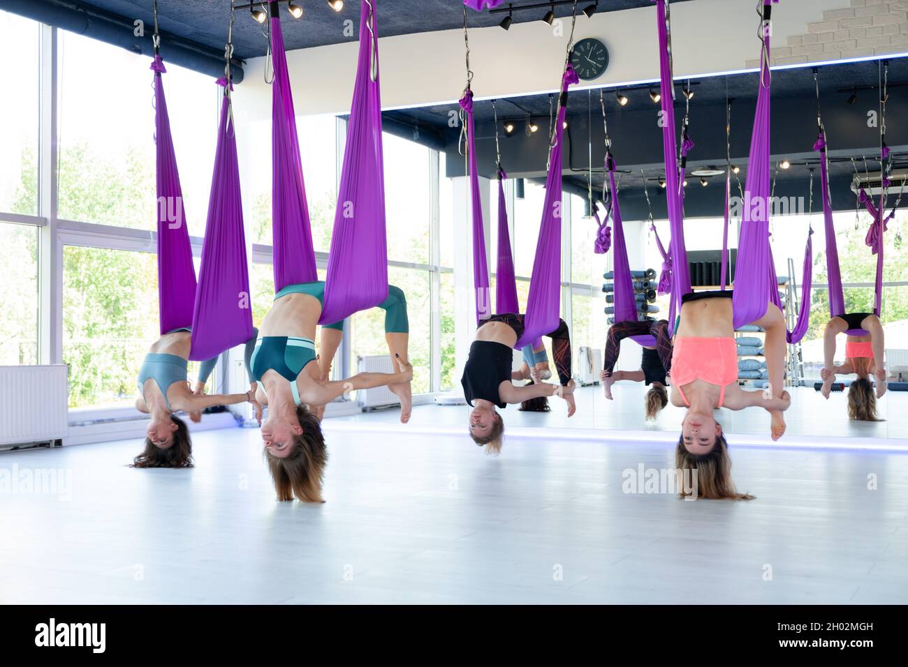Group of young women practice in aero stretching swing. Aerial flying ...