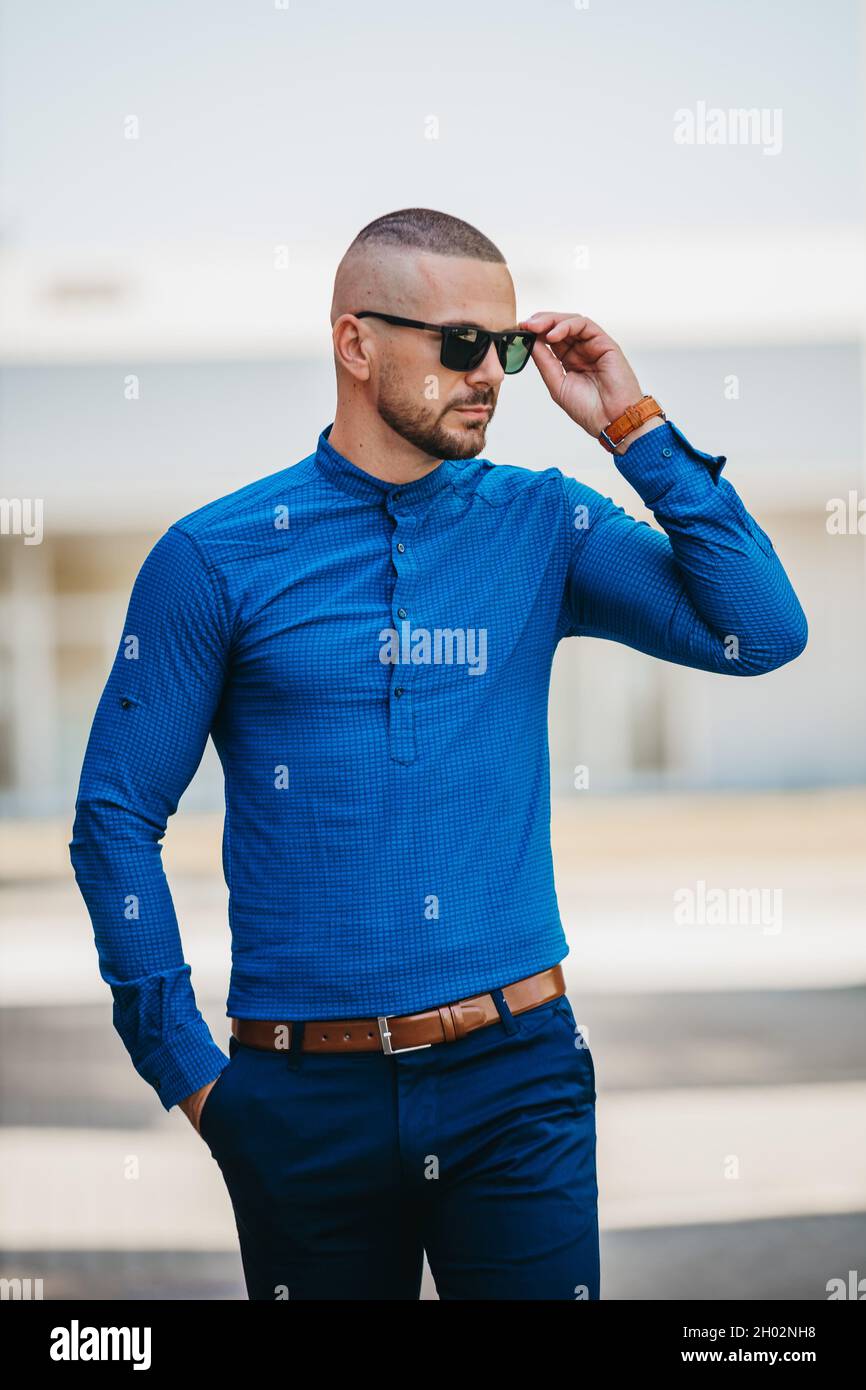 Cool handsome Caucasian man wearing an elegant blue shirt and ...