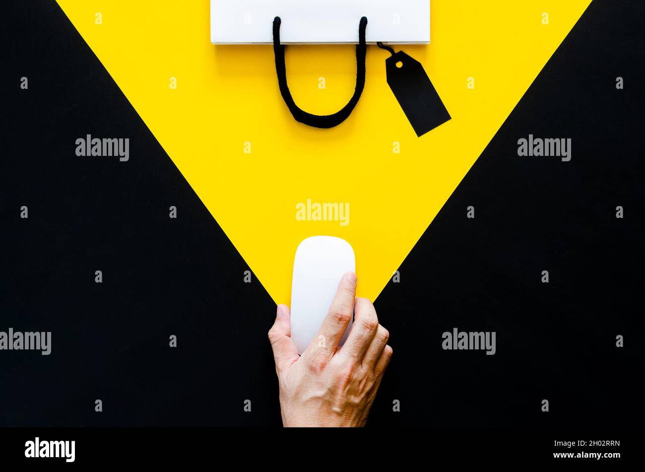 Hand holding wireless mouse for online shopping with yellow and black ...