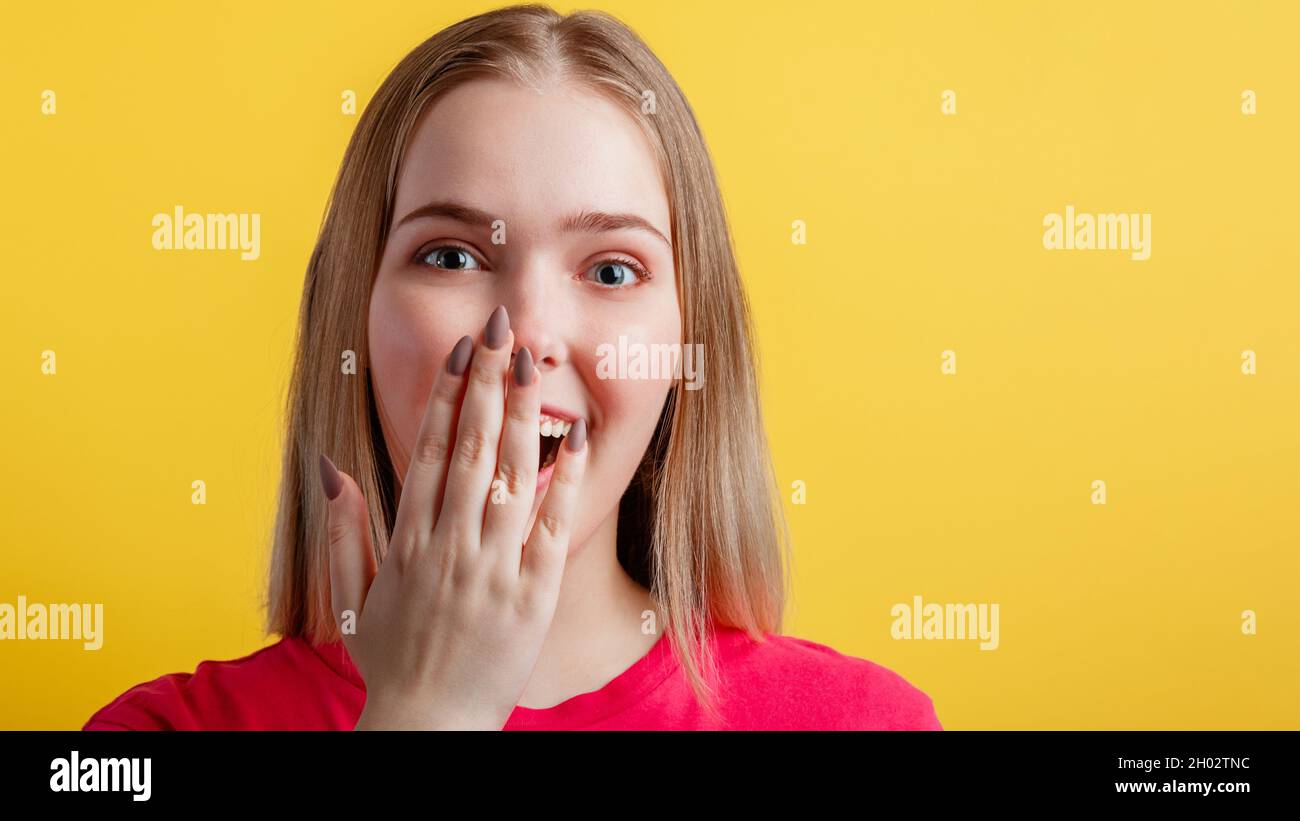 Young woman is pleasantly surprised. Teenage blonde girl covered her ...