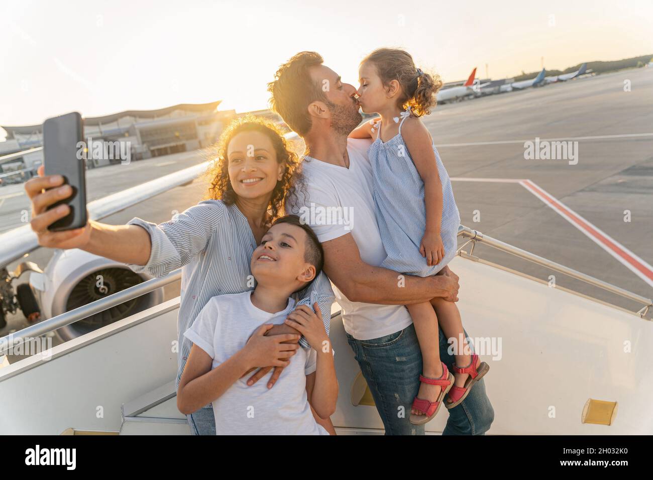 Happy family standing on ladder plane and going to travel Stock Photo ...