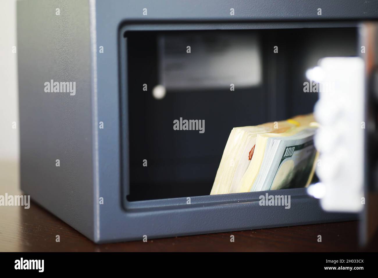 Steel safe with money. Hand putting password in the safety money box in ...