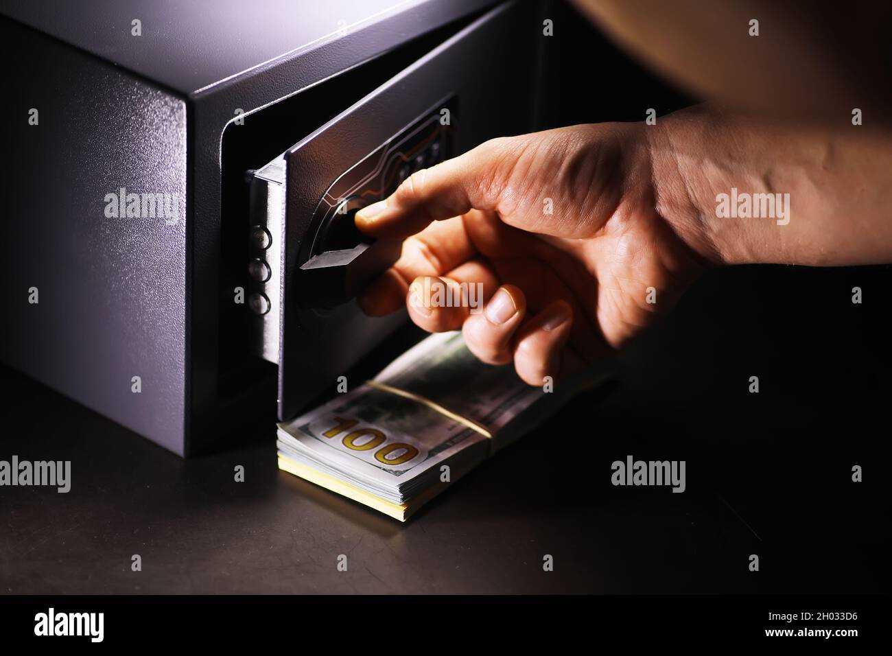 Steel safe with money. Hand putting password in the safety money box in ...